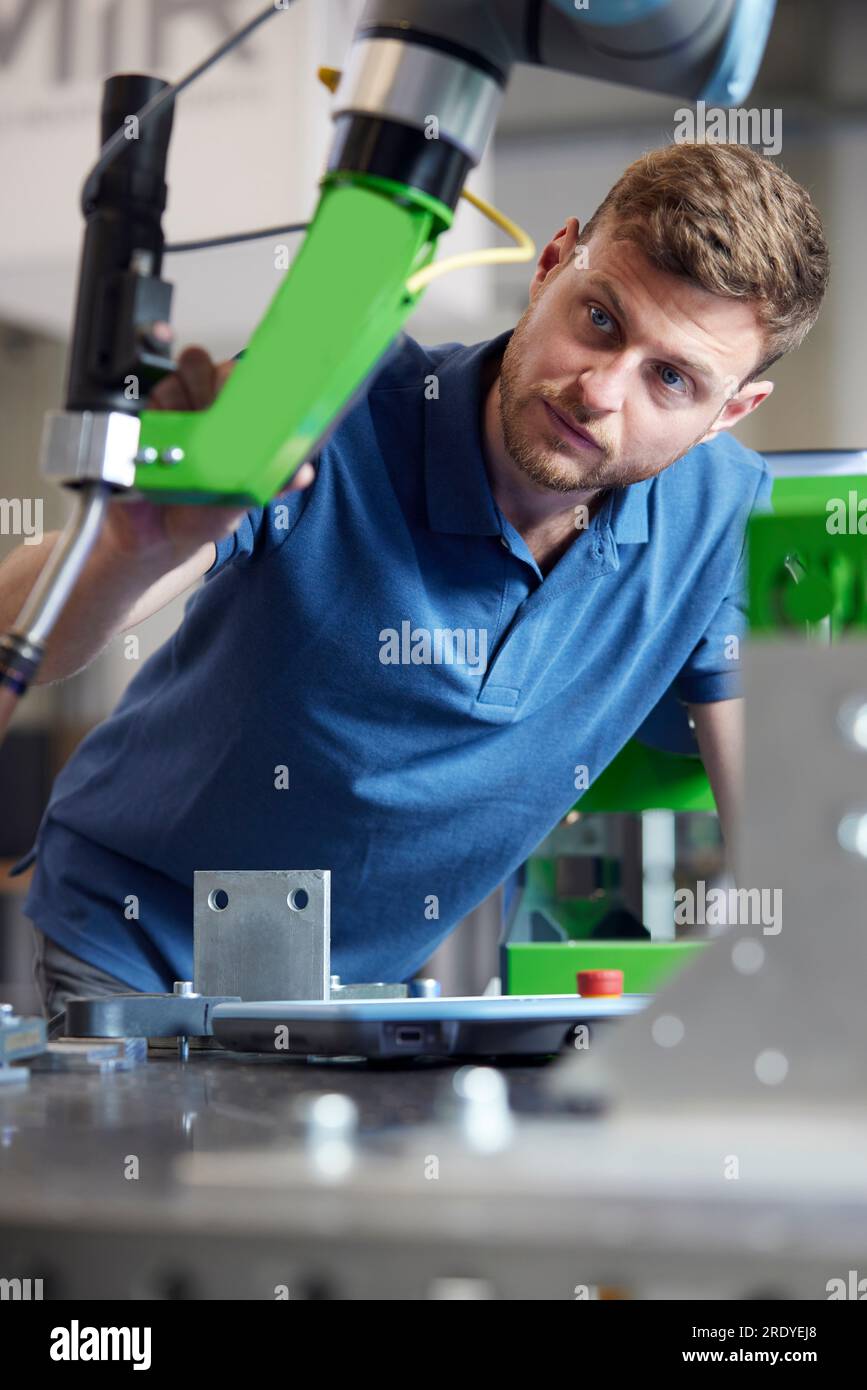 Focused engineer analyzing machine part in modern factory Stock Photo ...