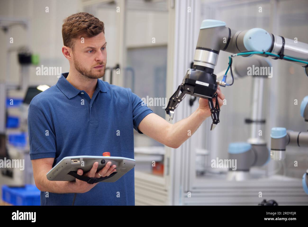 Engineer testing modern robotic arm in factory Stock Photo - Alamy