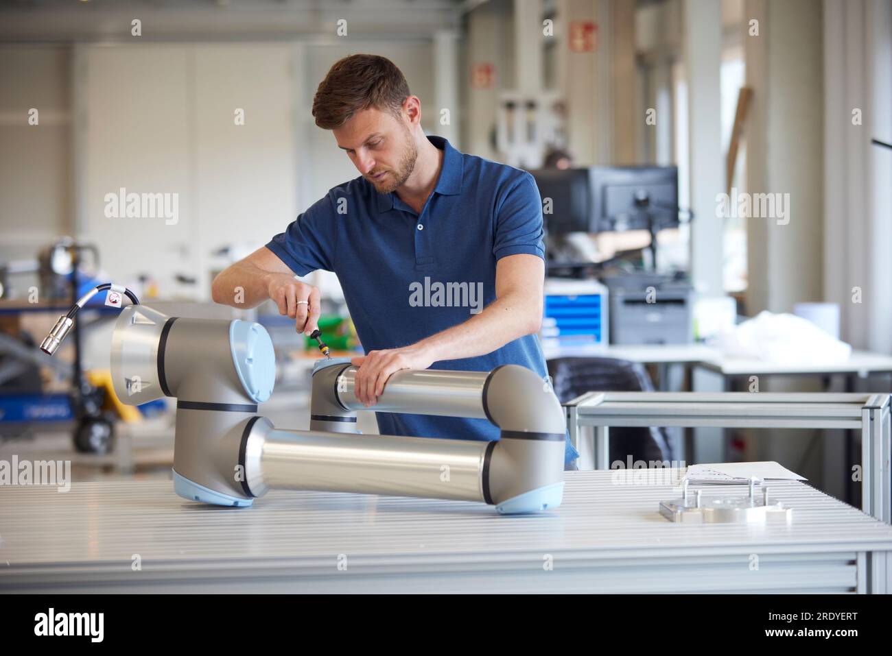 Focused engineer repairing robotic arm in industry Stock Photo - Alamy