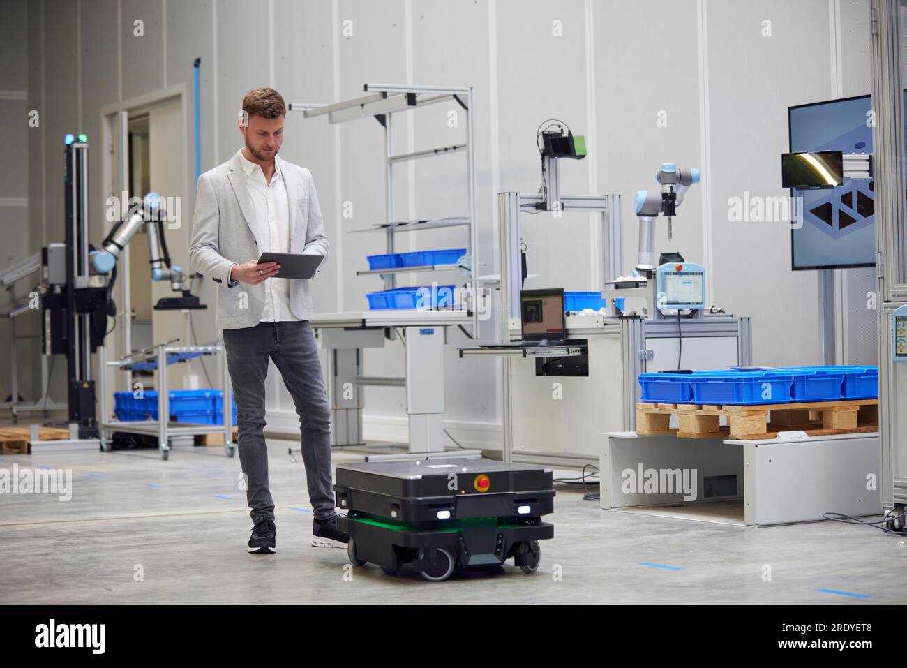 Engineer operating modern mobile robot in industry Stock Photo - Alamy