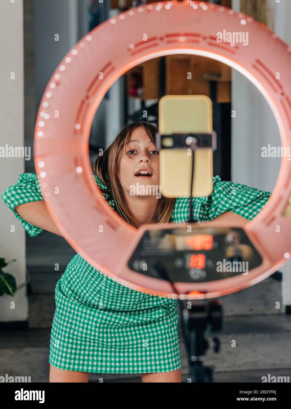 Girl making vlog in front of ring light Stock Photo - Alamy