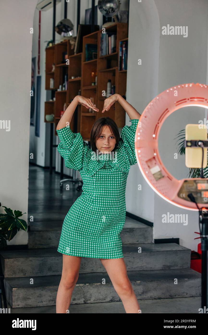 Girl gesturing and dancing in front of ring light Stock Photo - Alamy
