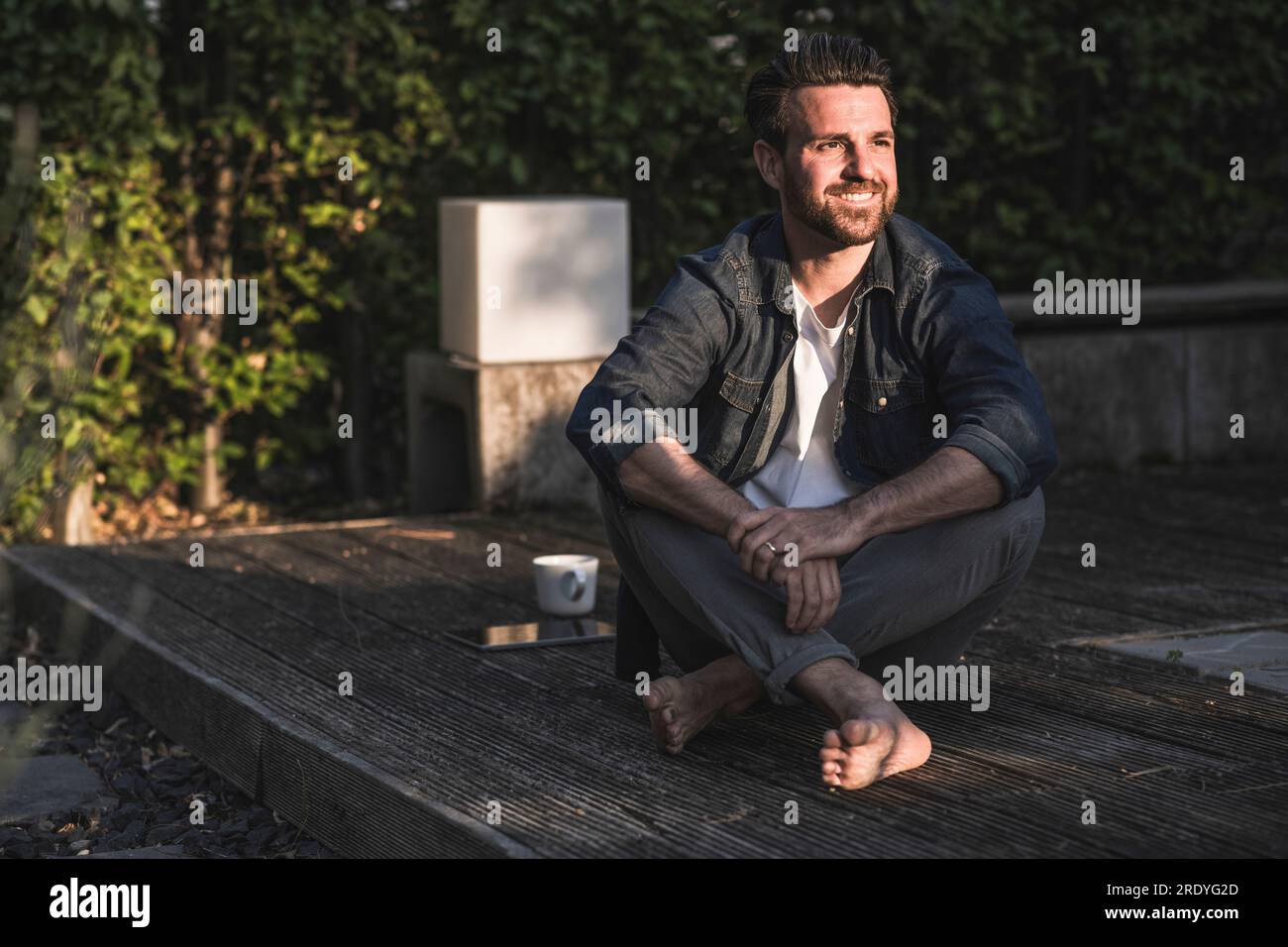 Thoughtful man sitting on porch Stock Photo - Alamy