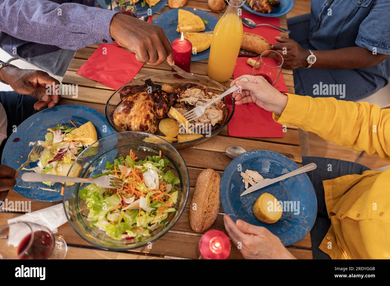 Multi-cultural senior friends enjoying food and drinks on dining table ...