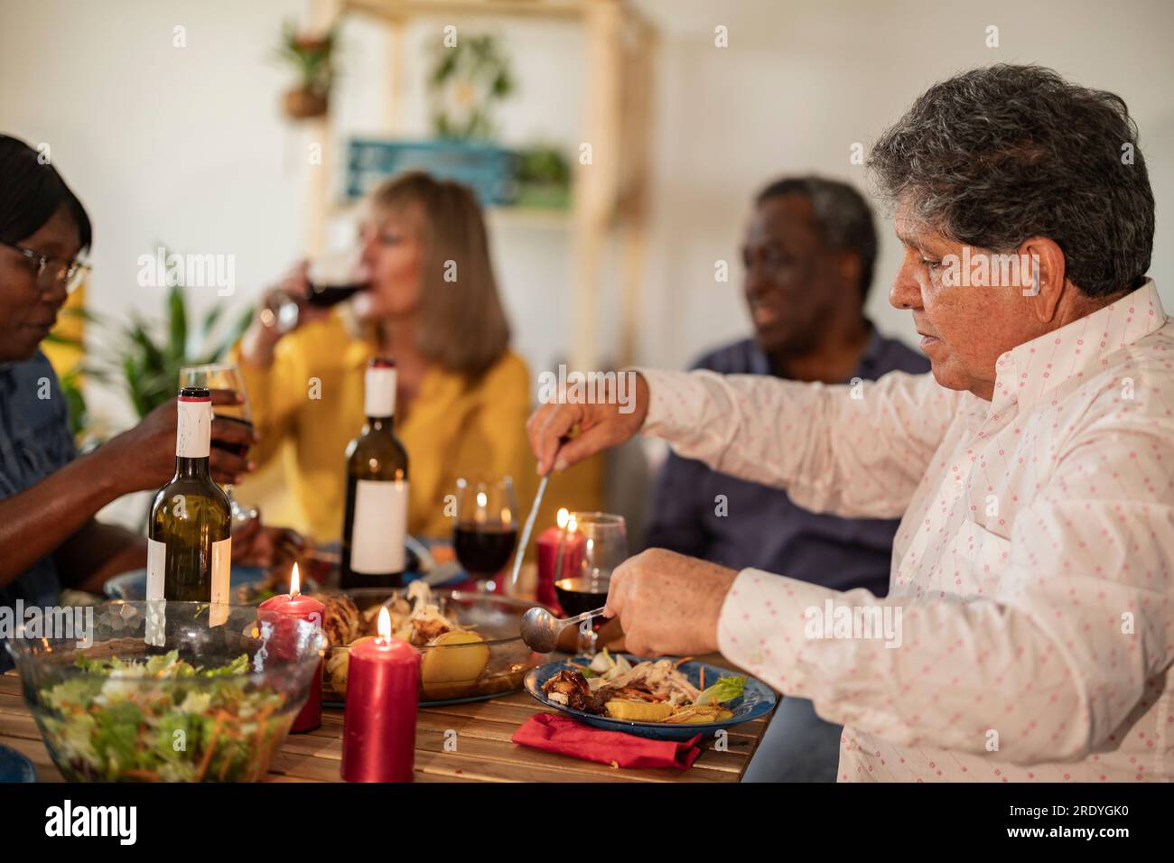 Senior man eating food with friends at dinner party Stock Photo - Alamy