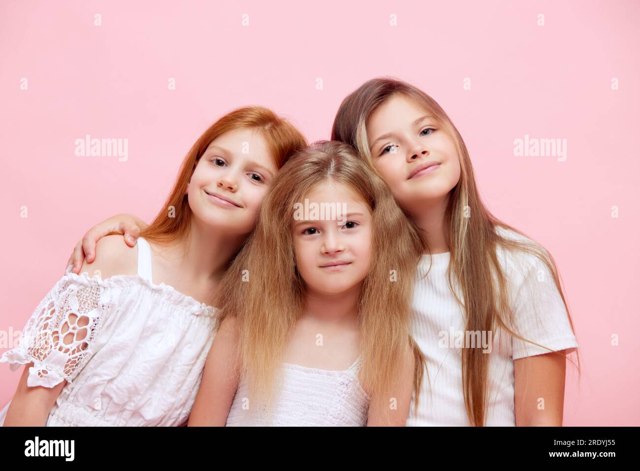 Three beautiful little girls, children in white clothes standing ...