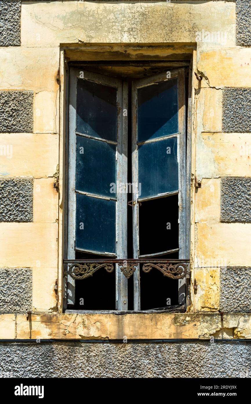 An old structure features a pair of broken windows, showcasing signs of ...