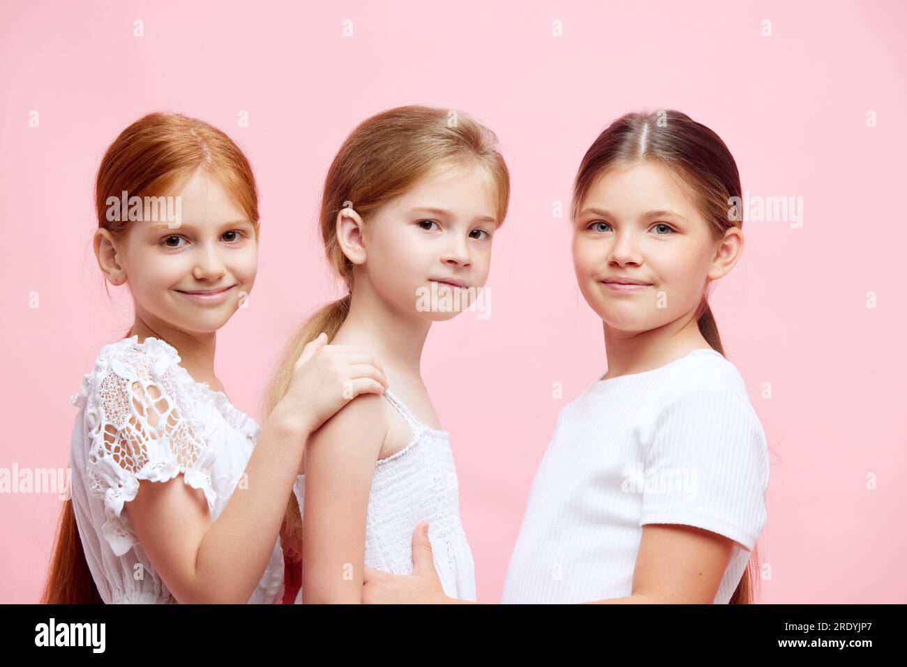 Portrait of beautiful three little girls, children in white clothes ...