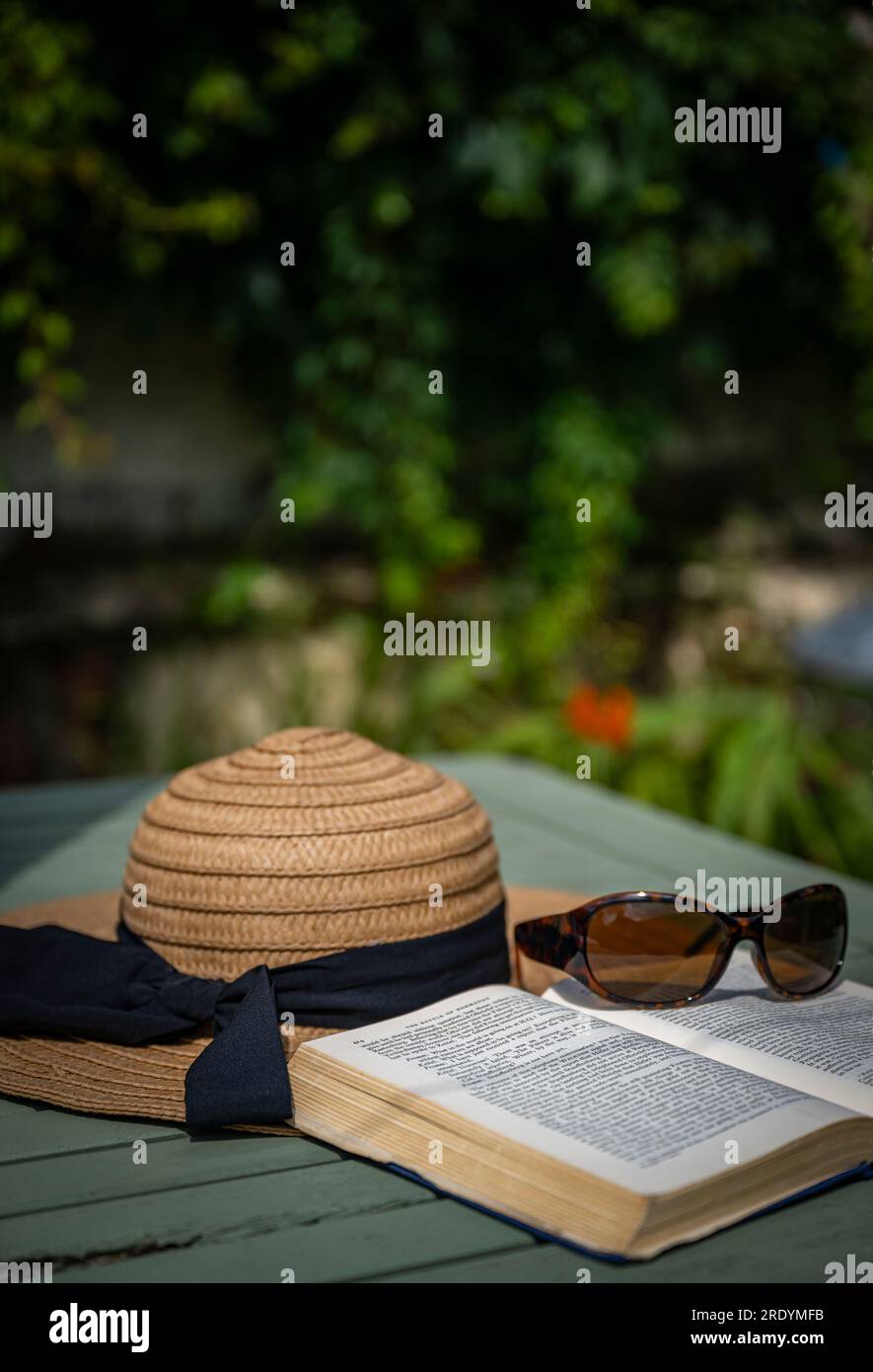 Summer iconic scene of a hot lazy summers day - a sun hat, book, a ...