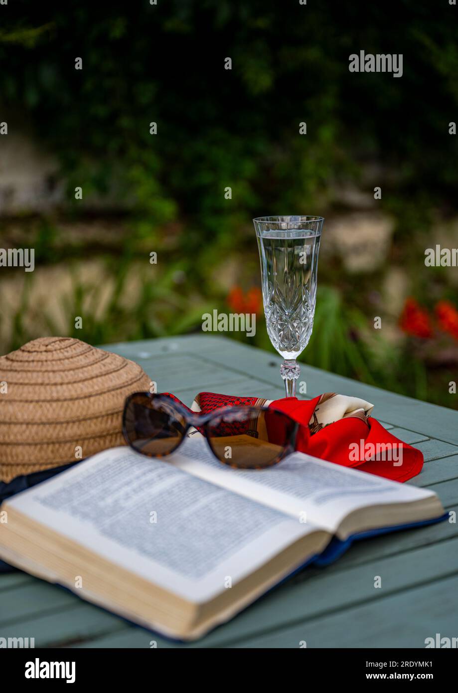 Summer iconic scene of a hot lazy summers day - a sun hat, book, a ...