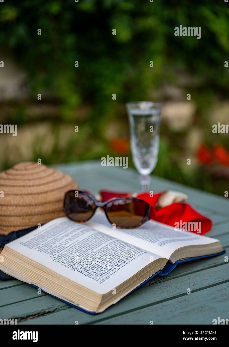 Summer iconic scene of a hot lazy summers day - a sun hat, book, a ...