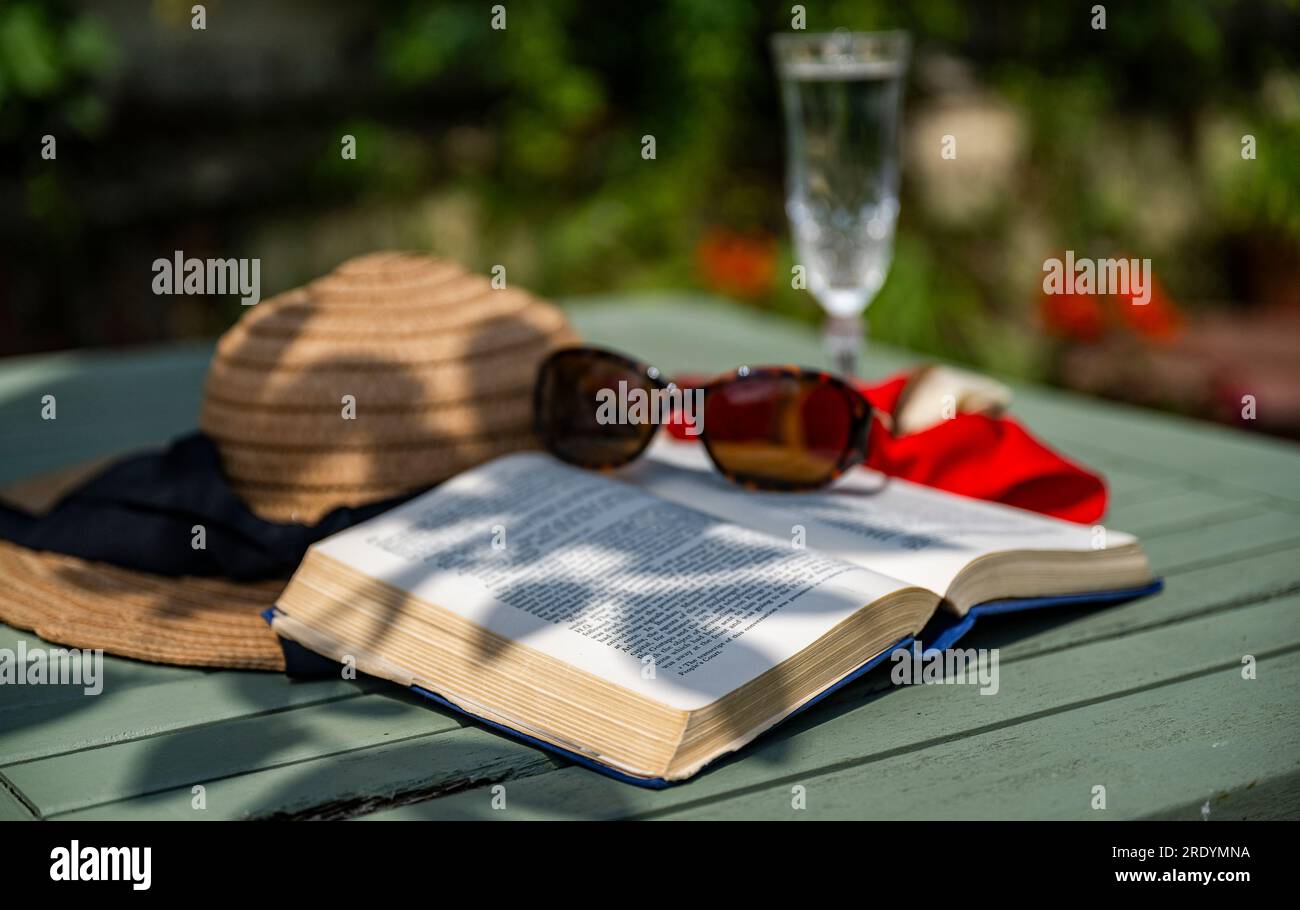 Summer iconic scene of a hot lazy summers day - a sun hat, book, a ...