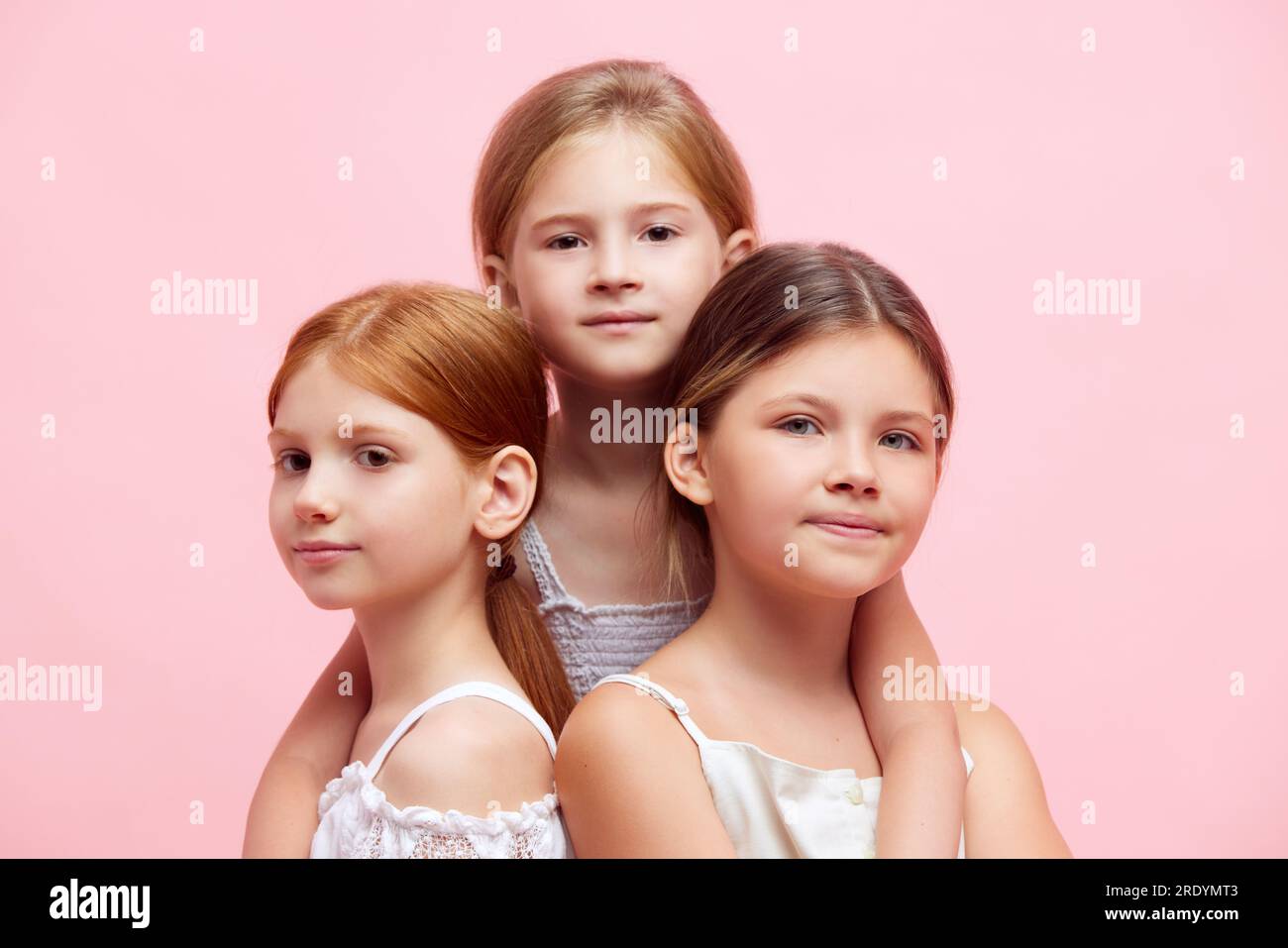Three beautiful little girls, children in white clothes standing ...
