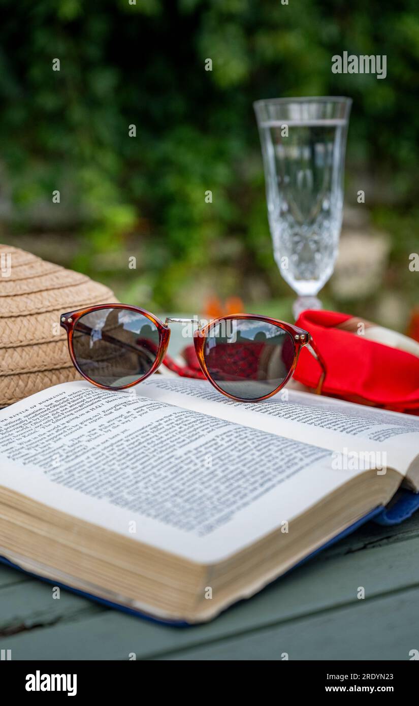 Summer iconic scene of a hot lazy summers day - a sun hat, book, a ...