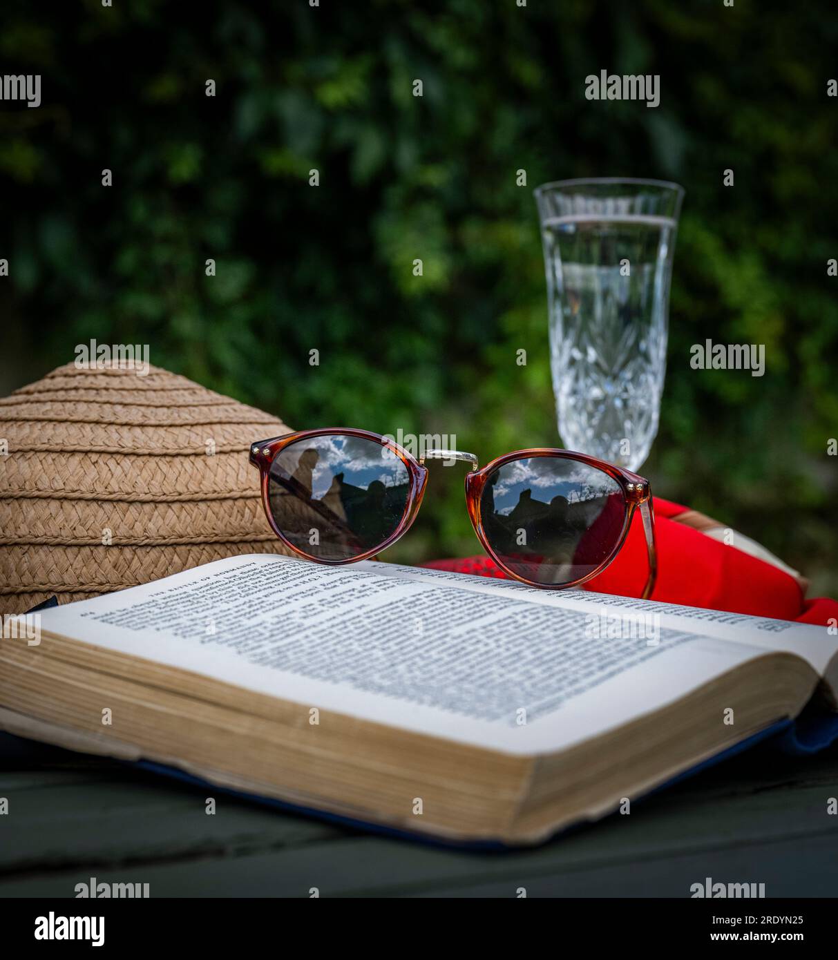 Summer iconic scene of a hot lazy summers day - a sun hat, book, a ...