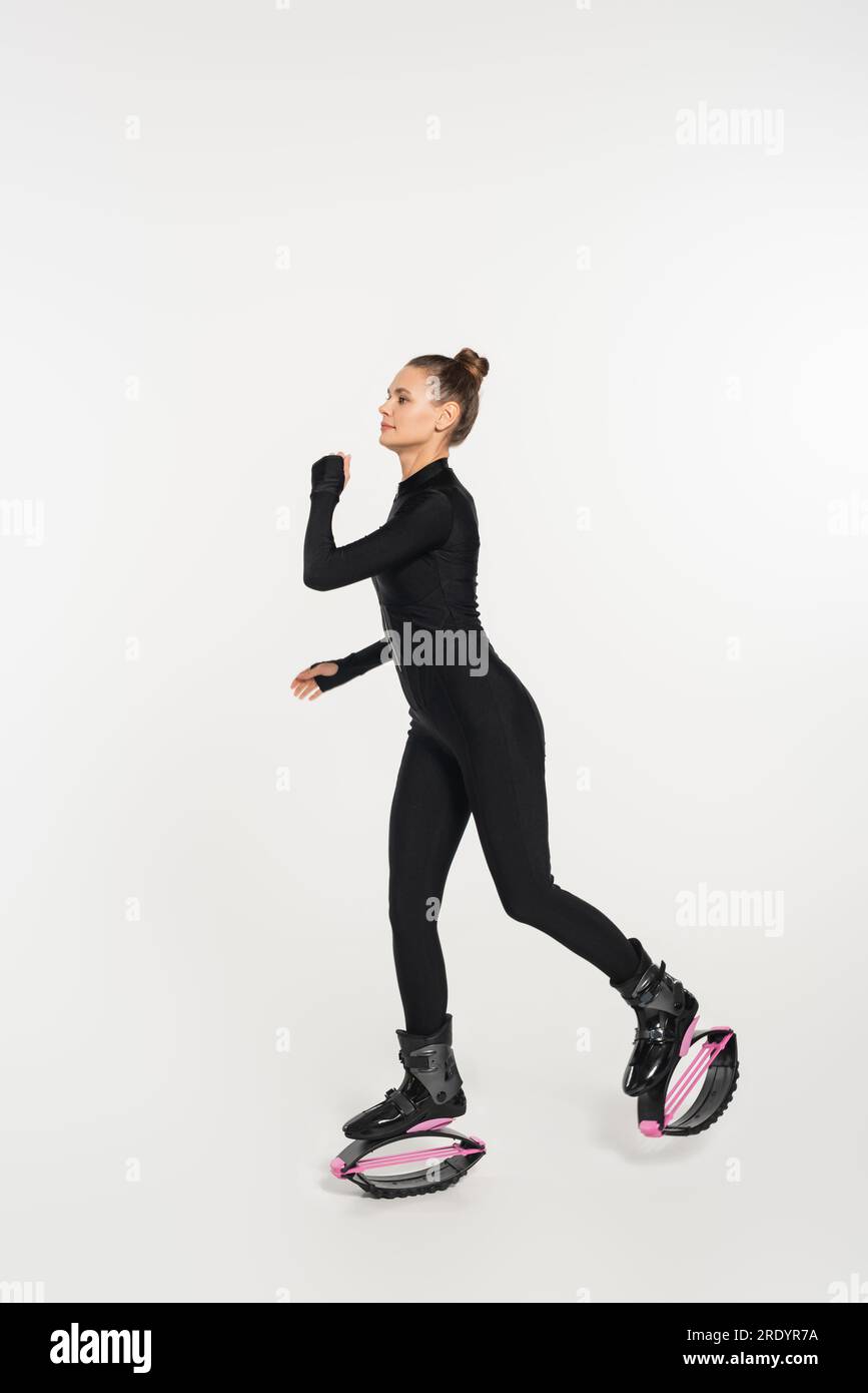 energy and strength, woman in kangoo jumping shoes exercising on white ...