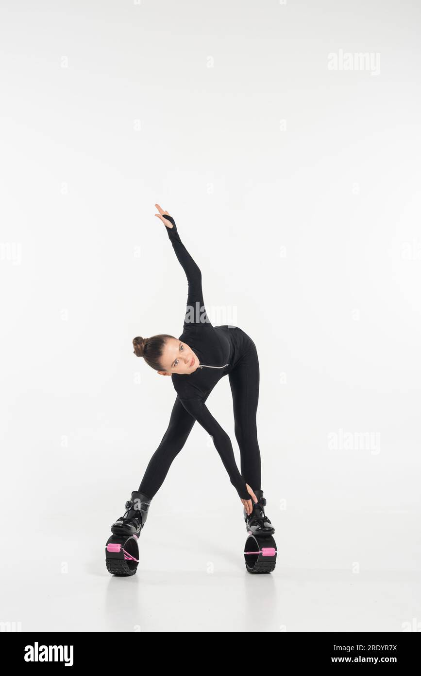 warm up, sportswoman in boots for jumping stretching body on white ...