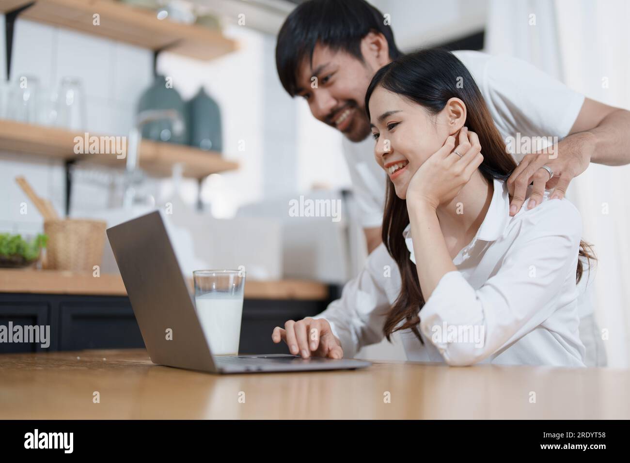 Young married couple showing happy smiling faces and using computers ...