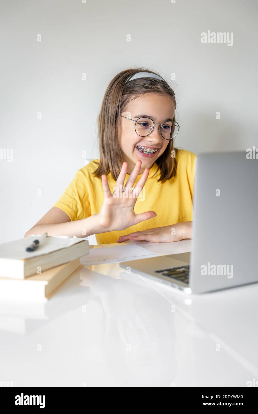Smiling caucasian girl having video call in remote classroom, using ...