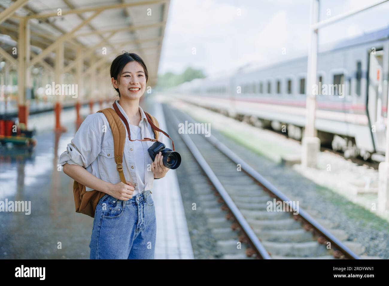 Asian teenage girl traveling using a camera take a photo to capture memories while waiting for a ...