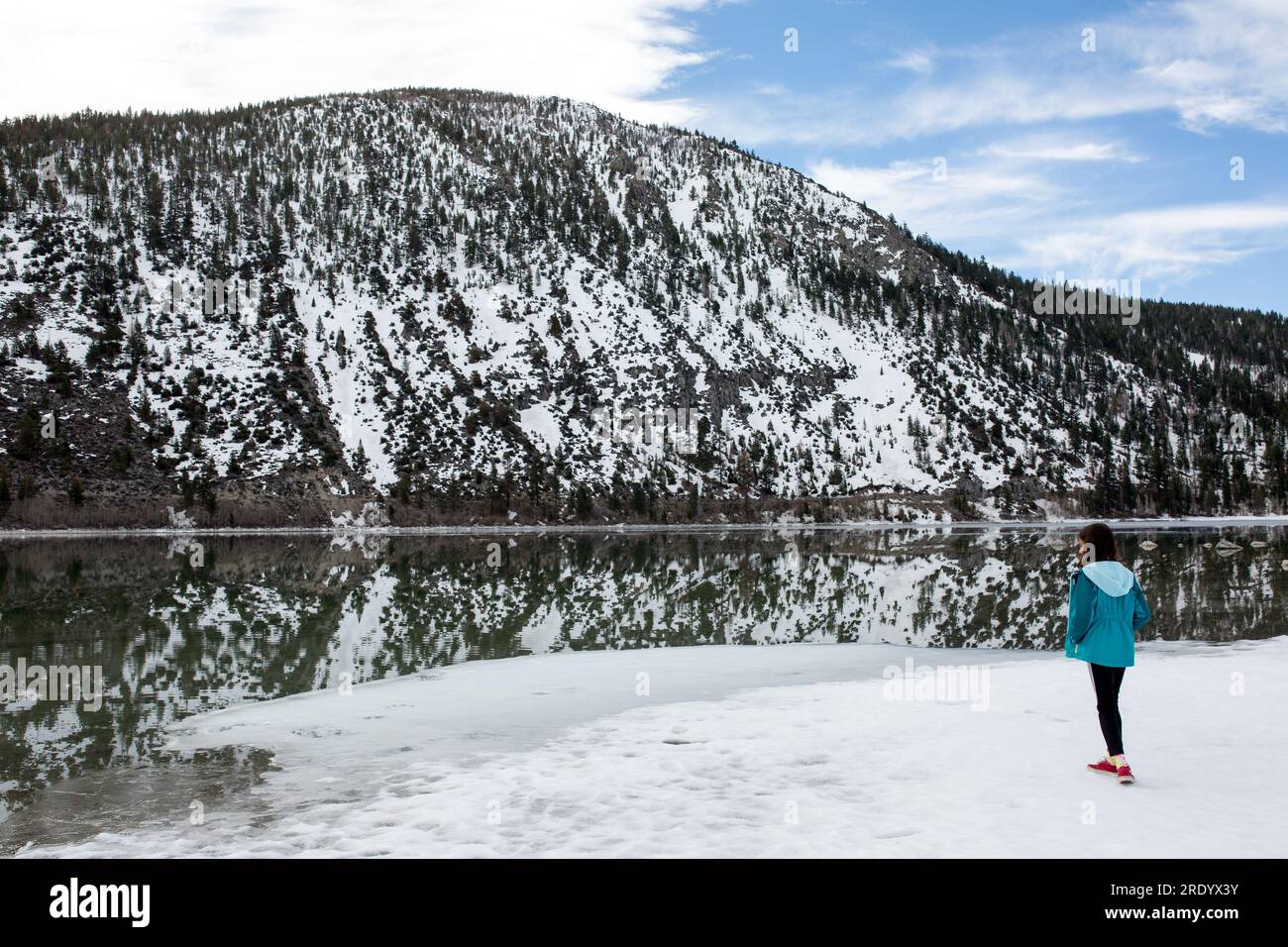 Girl walks on partially frozen June lake Stock Photo - Alamy