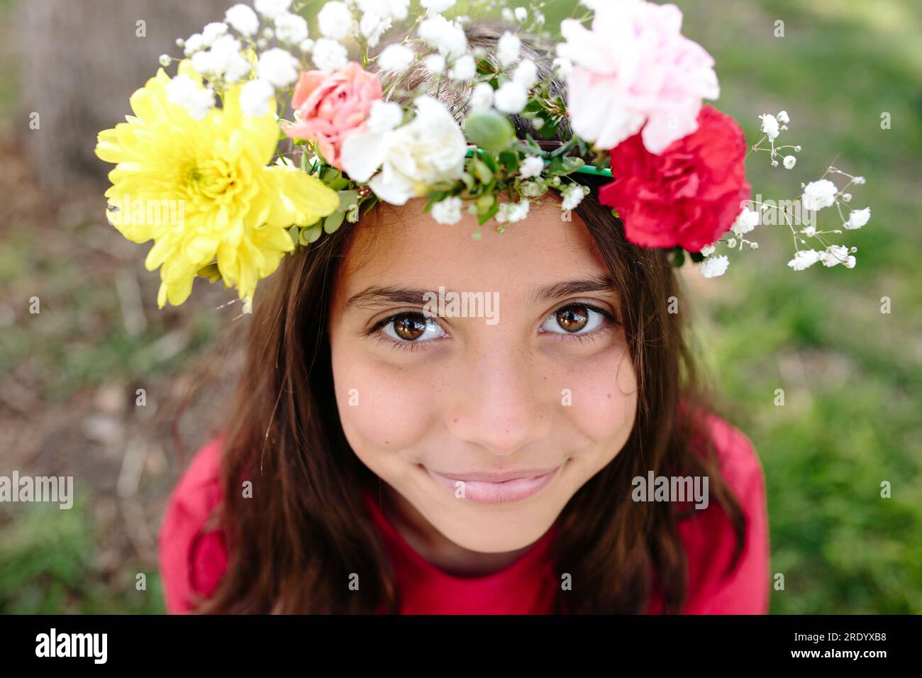 Tween girl smiles up at camera while wearing a flower head wreath Stock ...