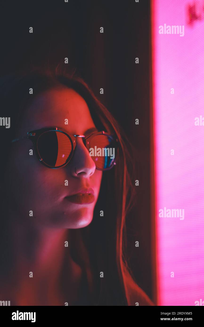 A girl next to a red neon light in the city Stock Photo - Alamy