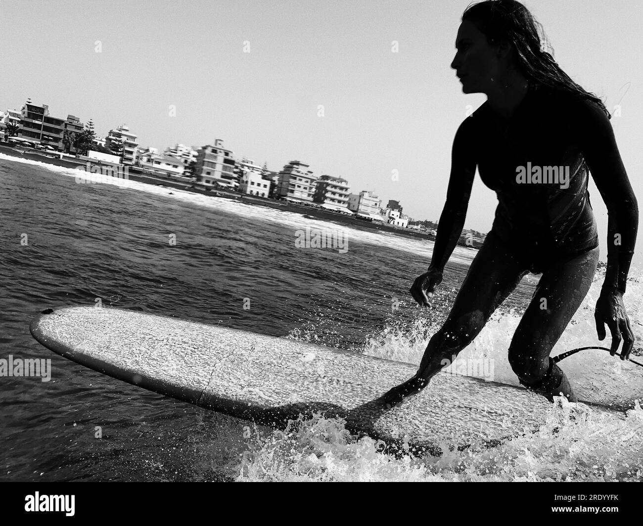 Close up silhouette view of female surfer on wave, black and white ...