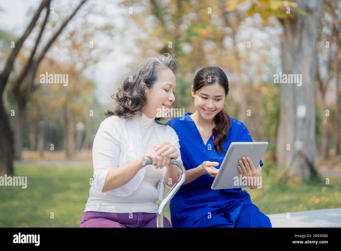 Patient care,, young Asian female nurse caring for with a cane and ...