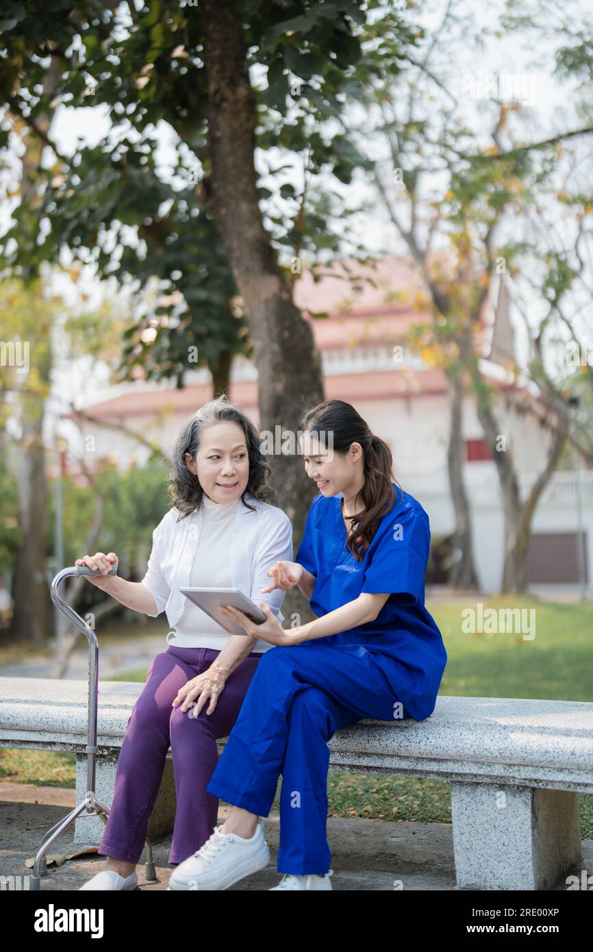 Patient care,, young Asian female nurse caring for with a cane and ...