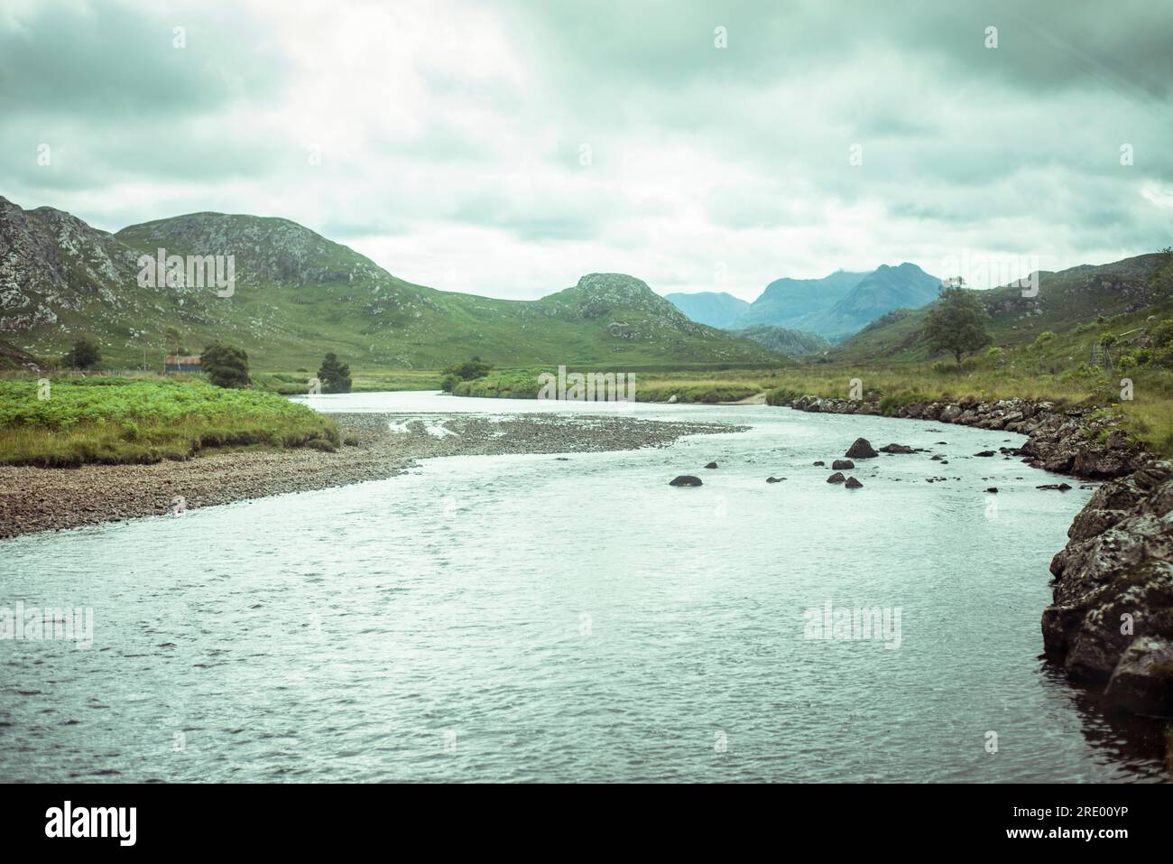 wild remote salmon river winds through mountains in scottish highlands ...