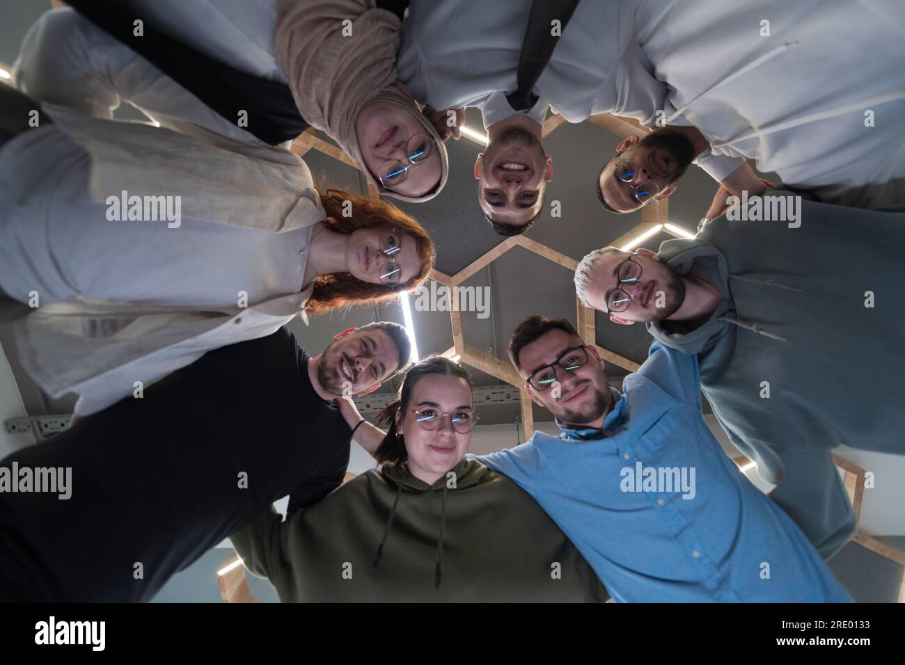 In a modern office, a group of young business professionals is captured ...