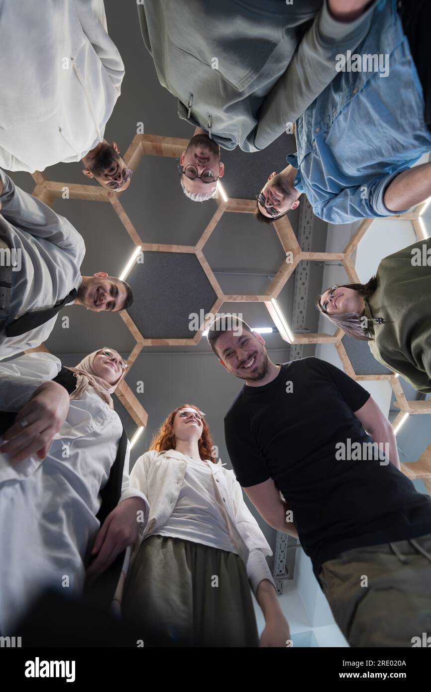 In a modern office, a group of young business professionals is captured ...