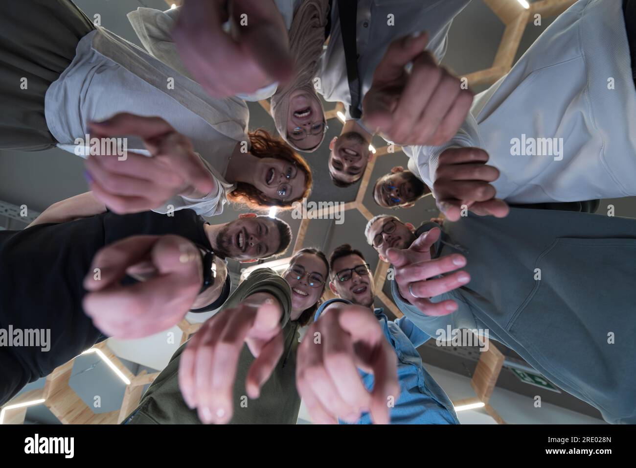 In a modern office, a group of young business professionals is captured ...