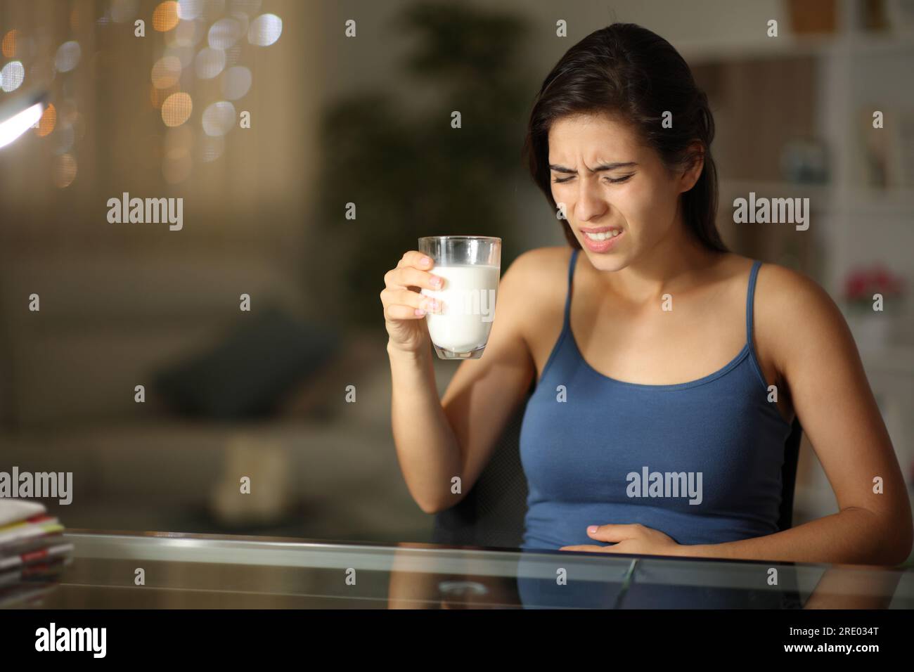 Woman suffering lactose intolerance after drinking milk in the night at ...