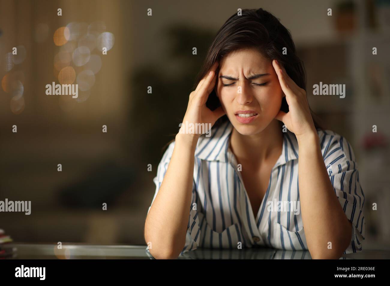 Front view portrait of an stressed woman suffering migraine in the ...