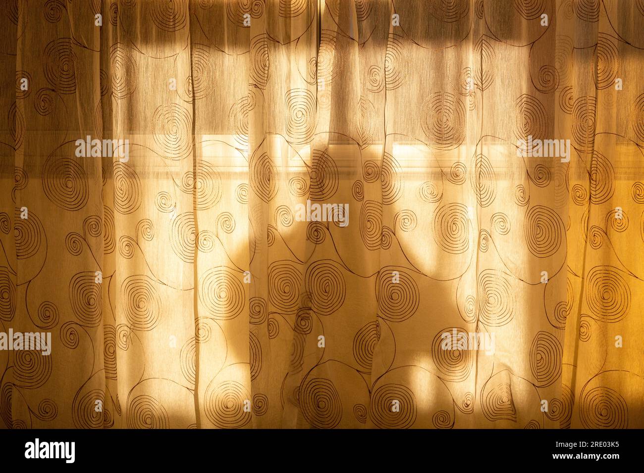 Silhouette stood out against the light through a curtain at sunset ...