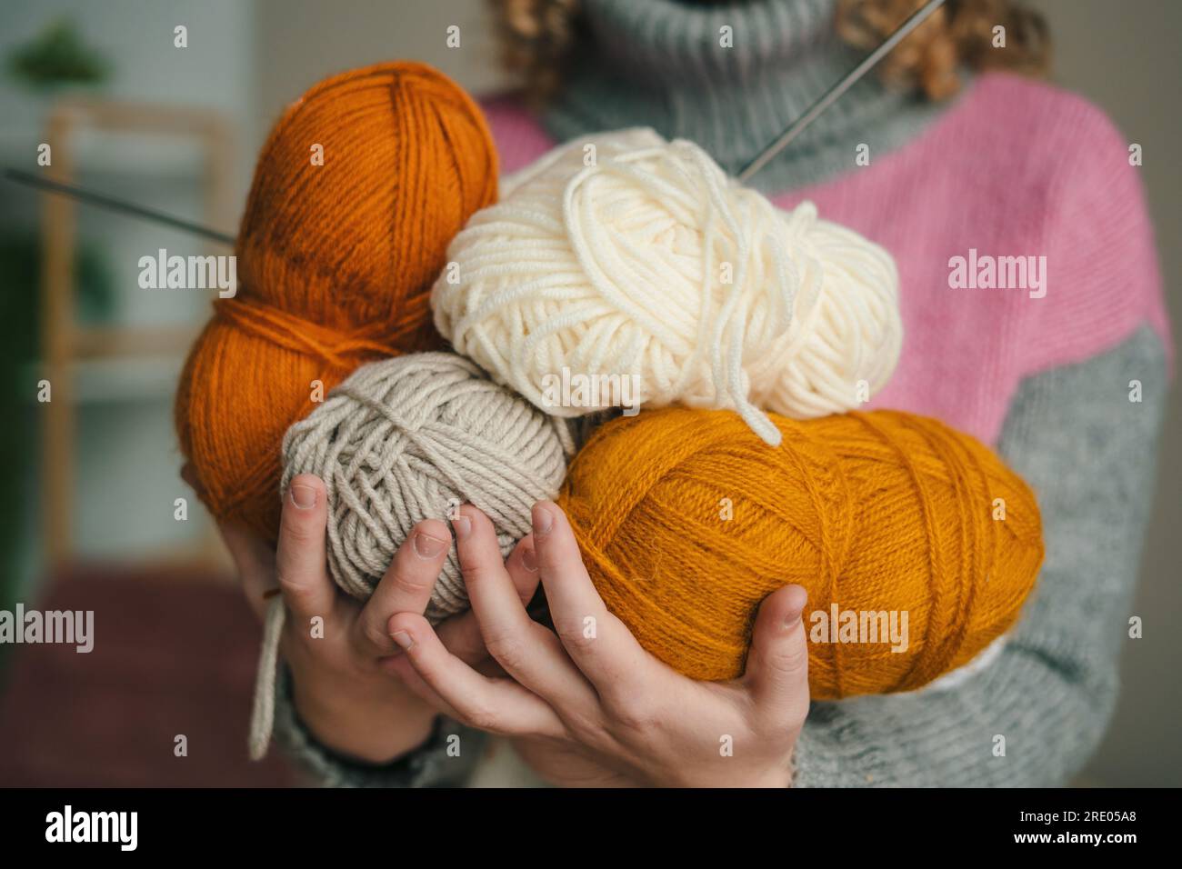 Woman hands with knitted toys, balls of thread and knitting needles ...