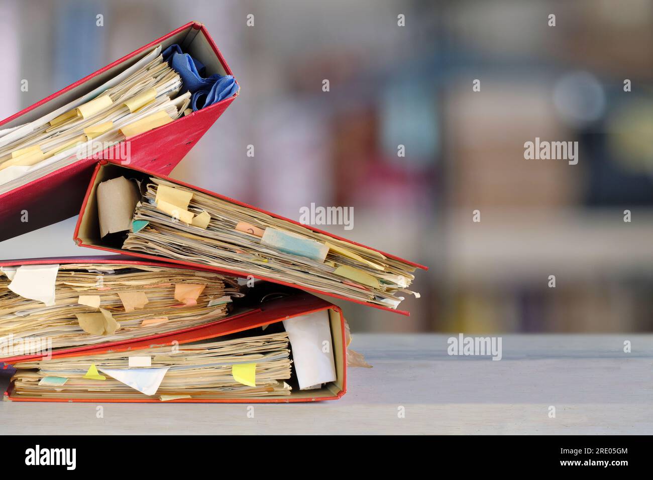 stack of dusty messy file folders with narrow depth of field, blurred ...