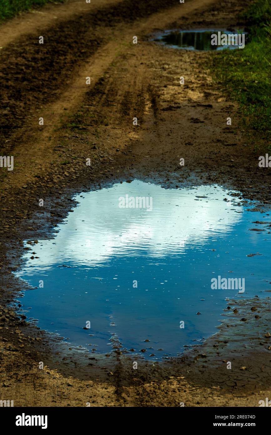 Cloud reflecting in a puddle on a path Stock Photo - Alamy