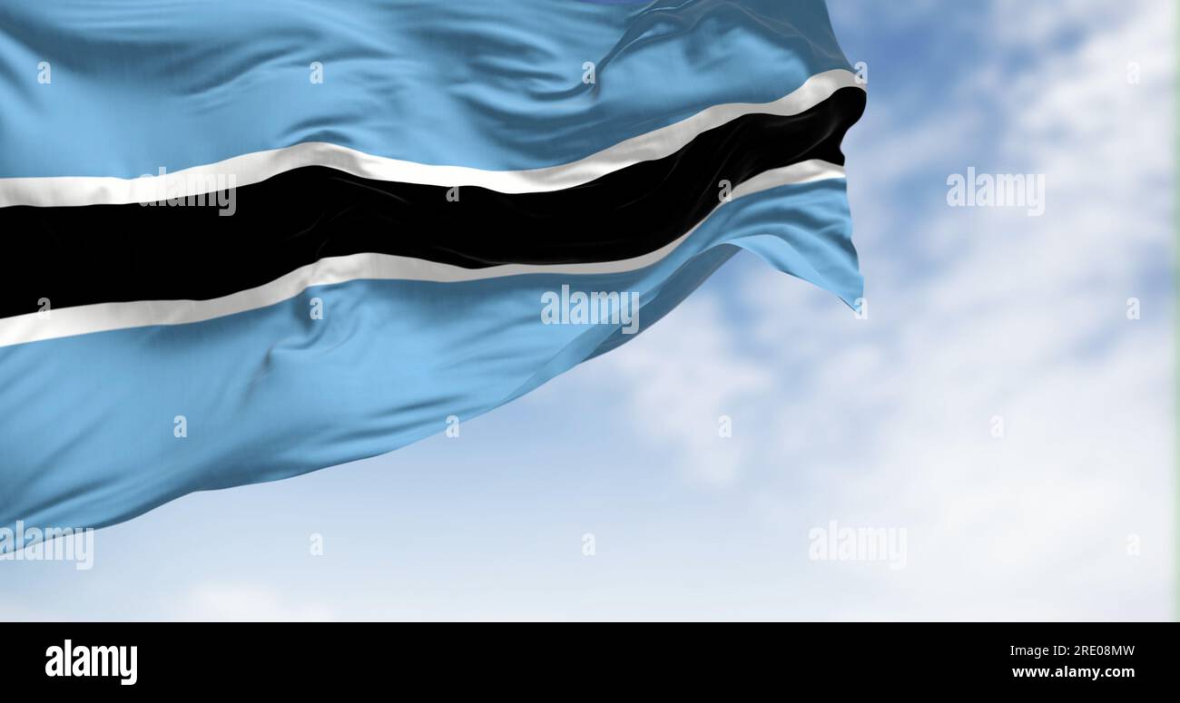 National flag of Botswana waving in the wind on a clear day. Light blue field with a horizontal ...