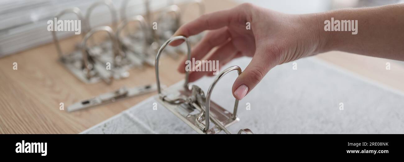The hand inserts the ring mechanism into the folder Stock Photo - Alamy