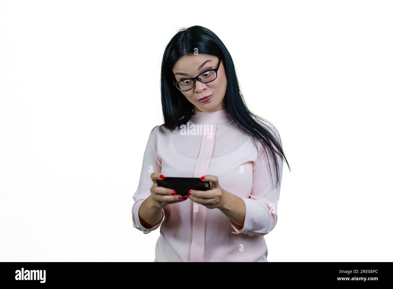 Expressive young asian woman playing video game with her eyes wide open ...