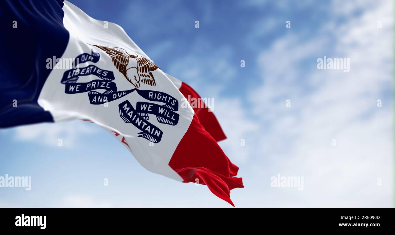 Iowa state flag waving in the wind on a clear day. Three vertical ...