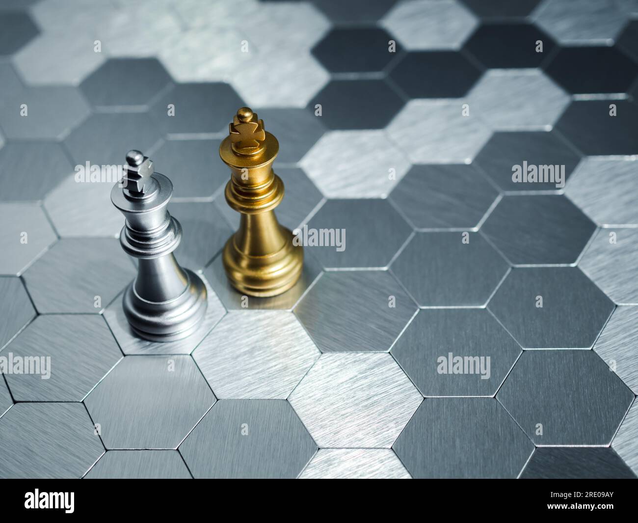 A golden king chess piece and a silver king chess piece are standing ...