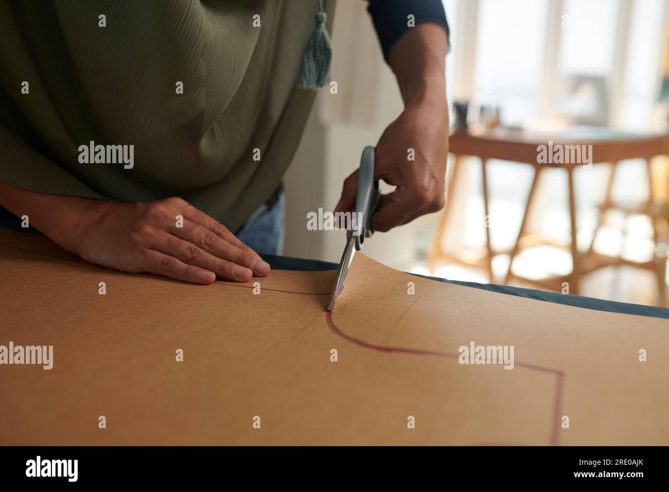 Closeup image of tailor cutting out paper sewing pattern Stock Photo ...