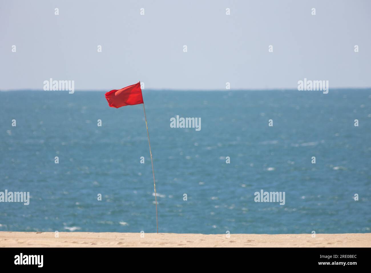 Red flag by the sea - warning sign Stock Photo - Alamy