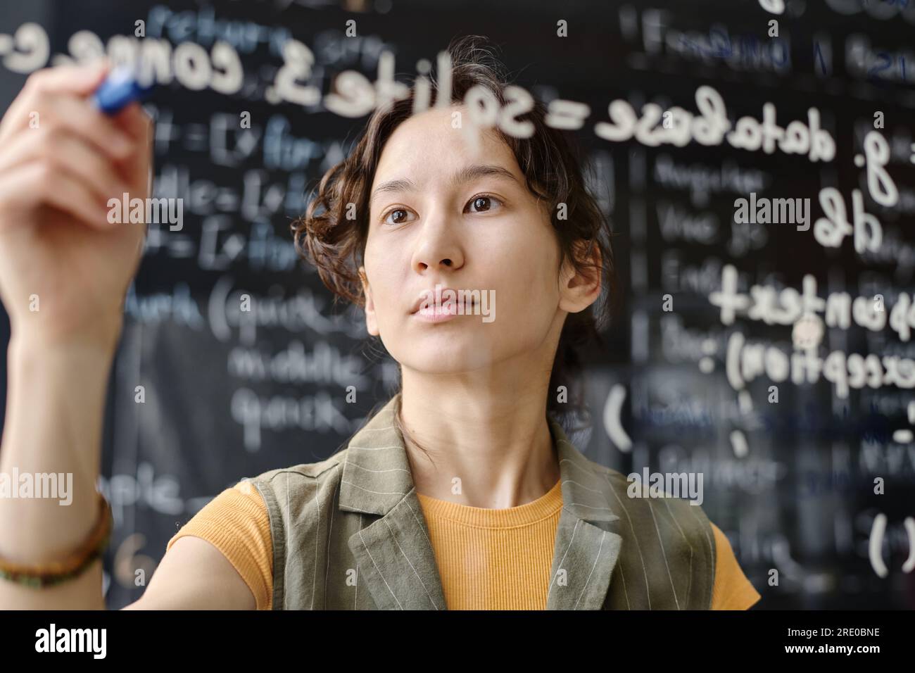 Student writing on blackboard in the classroom at school Stock Photo ...