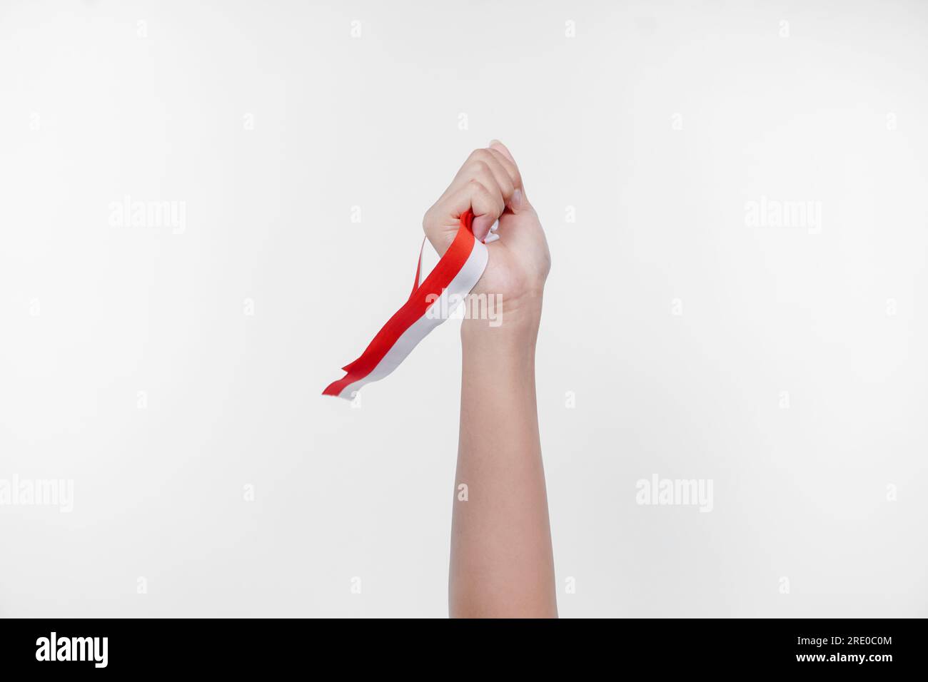 hands put together holding Indonesian red and white ribbon. Indonesia's ...