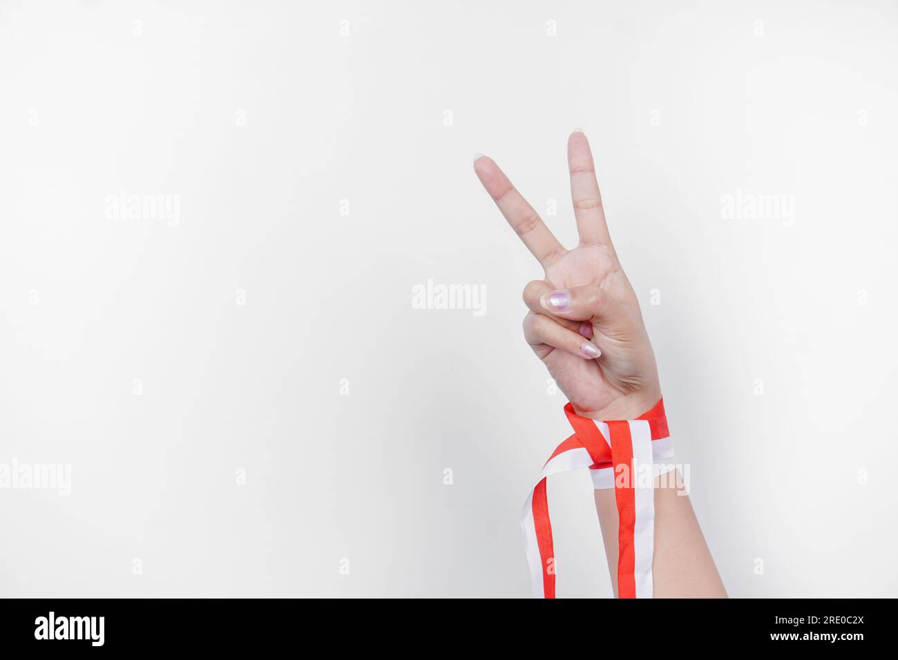 hands gesturing signs of number wearing Indonesian red and white ribbon ...